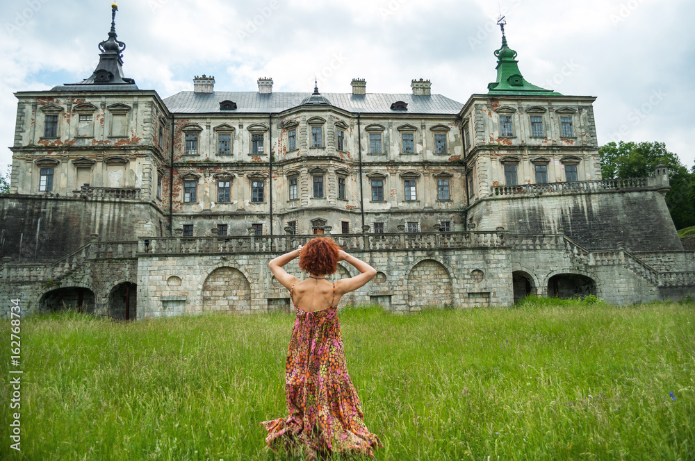 Beautiful young woman in dress standing back in castle Stock Photo ...