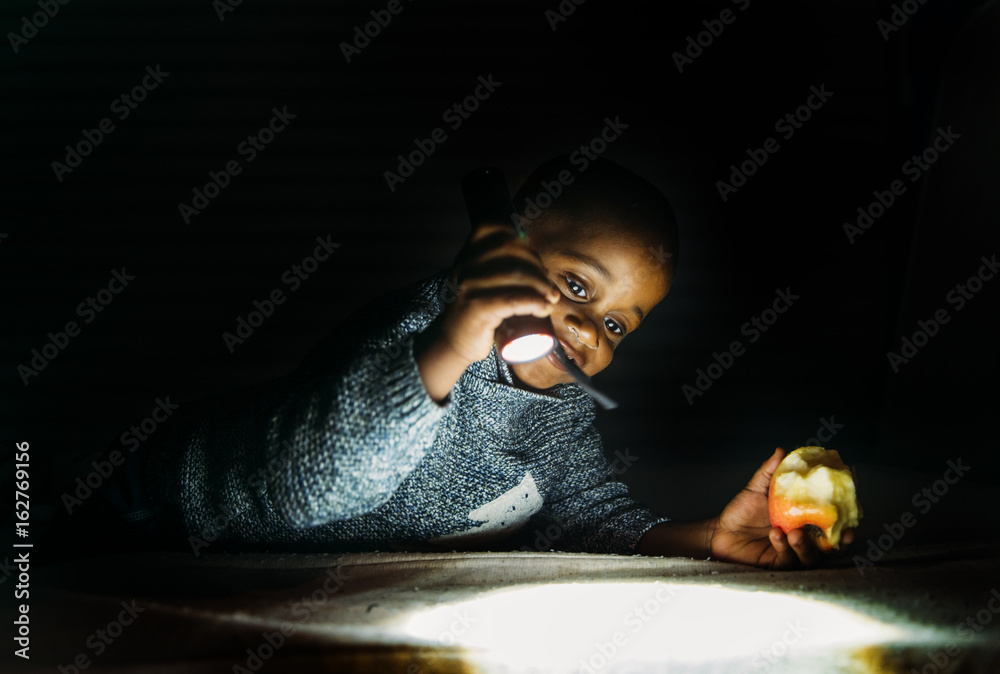 Black child with flashlight Stock Photo | Adobe Stock