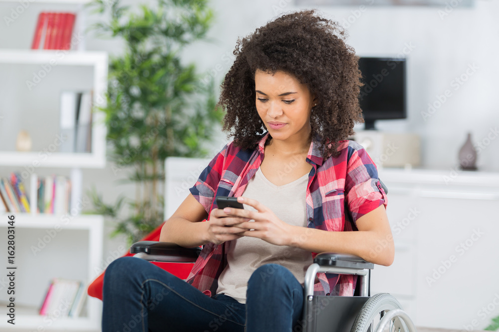 disabled woman in wheelchair on mobile phone Stock Photo | Adobe Stock