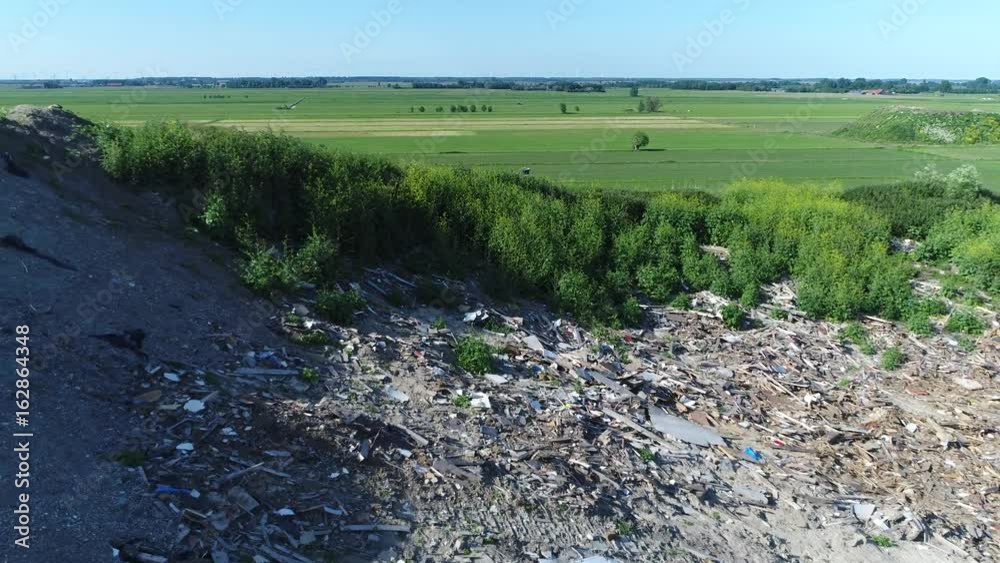 Aerial bird eye view of landfill site drone flying backwards showing ...