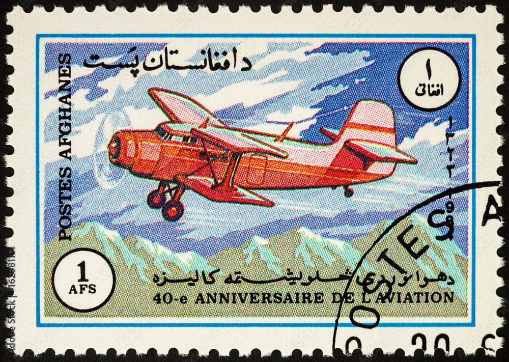 Old aircraft over mountains on postage stamp Stock Photo | Adobe Stock