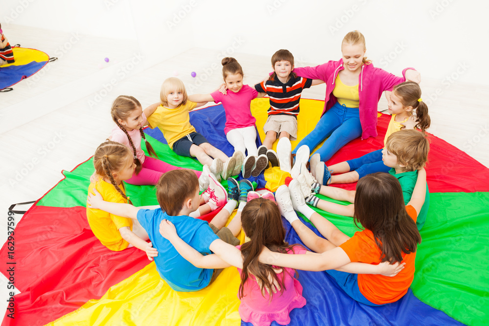 Happy children playing circle games with teacher Stock Photo | Adobe Stock