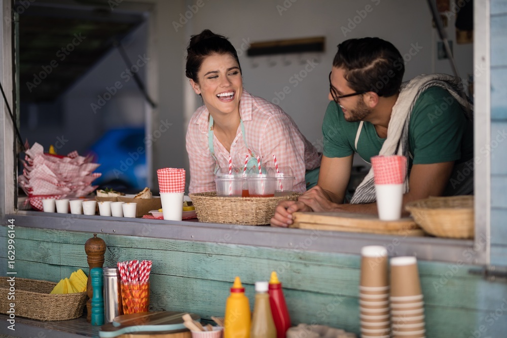 Waiter and waitress interacting at counter Stock Photo | Adobe Stock