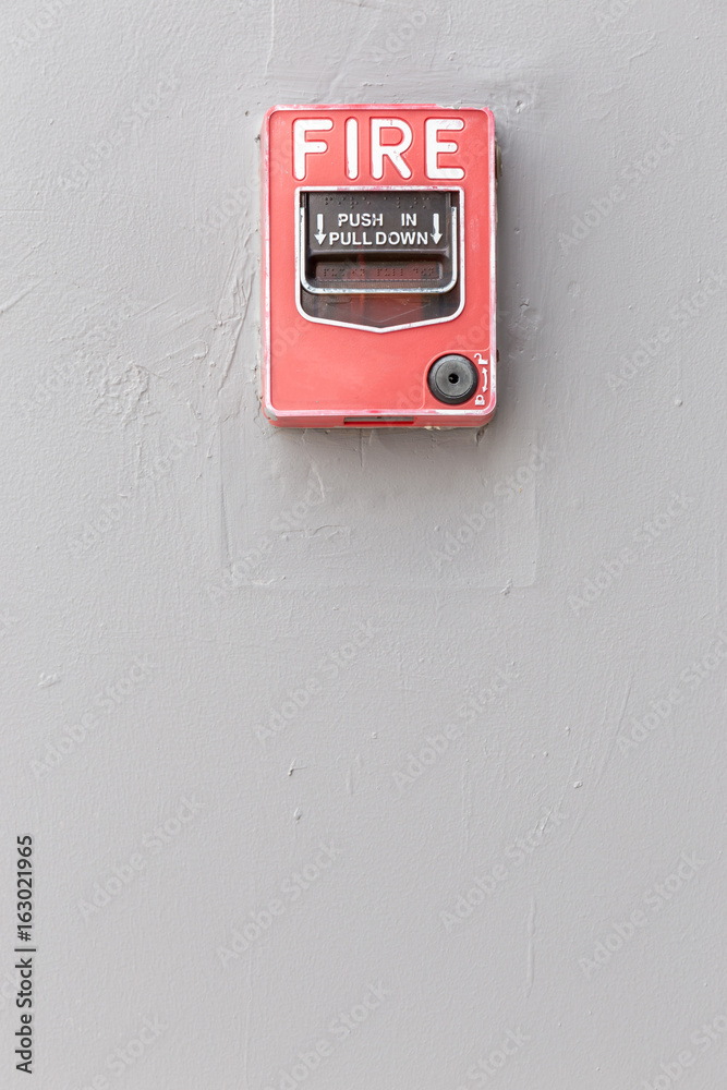 Red fire alarm switch on exterior cement wall of commercial building ...