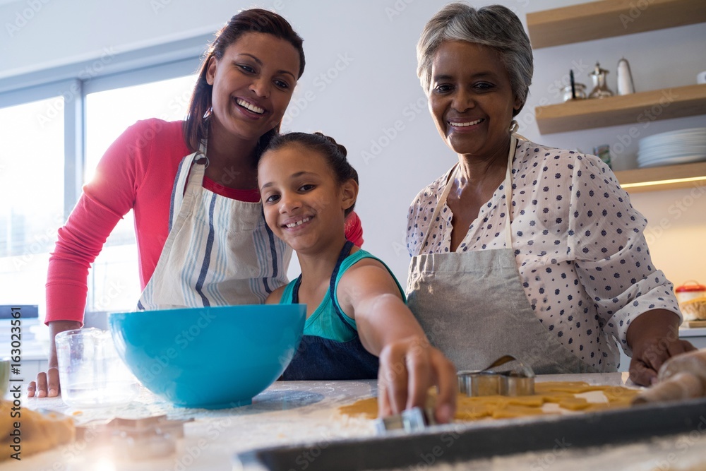 Happy multi-generation family preparing cookies in kitchen Stock Photo ...