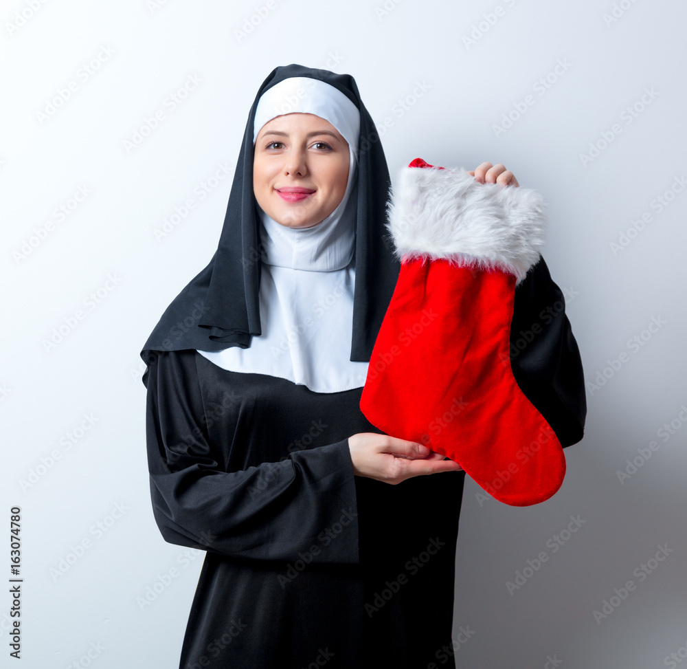 Young smiling nun with Christmas sock Stock Photo | Adobe Stock