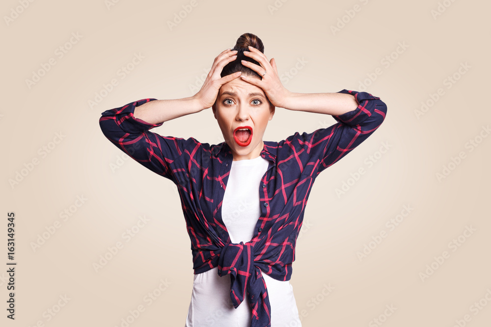 Portrait of hysterical Caucasian girl with bun hair looking in despair ...