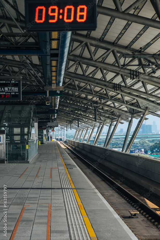 Empty high speed train platform with a digital clock read 9:08 and no ...