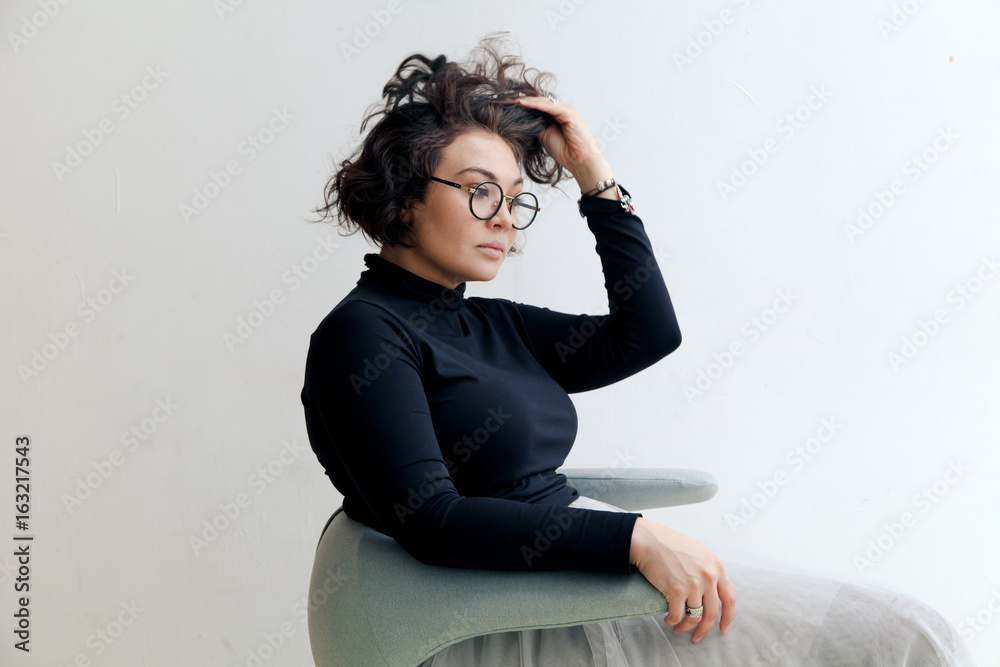 Young plus size female model in tutu skirt sitting in chair stretching ...