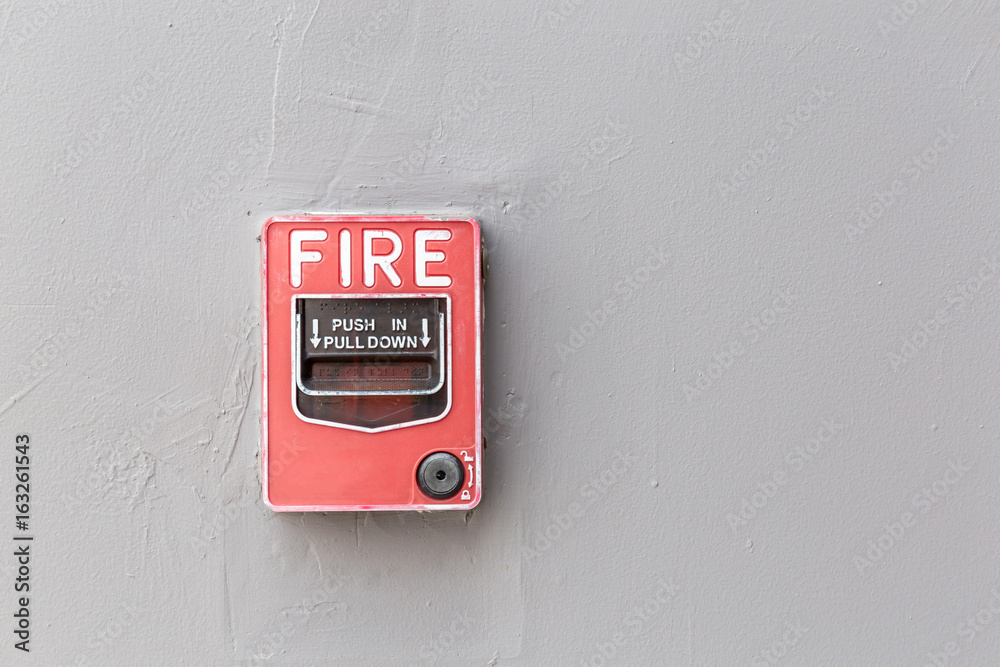 Red fire alarm switch on exterior cement wall of commercial building ...