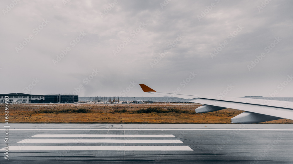 Wide angle view from aircraft window of take-off runway with stripes of ...