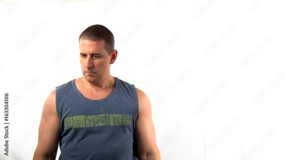 Attractive muscular middle age man works his biceps with dumbbells as ...