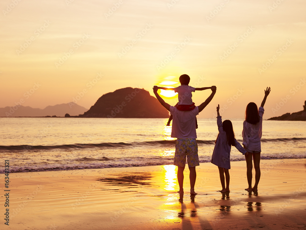 asian family watching sunrise or sunset on beach Stock Photo | Adobe Stock