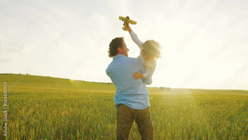 Father raising up his son to the sky. Father and son playing together ...