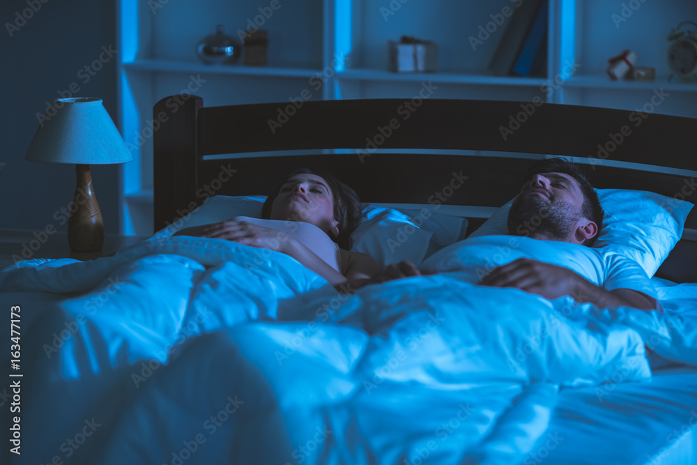 The man and woman sleeping in the comfortable bed. night time Stock ...