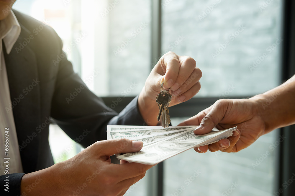 Man is handing money to real estate agent gives house keys to his ...
