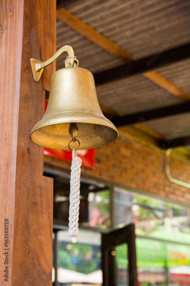 hand holding the rope of Gold retro bell under the roop with sunshine ...