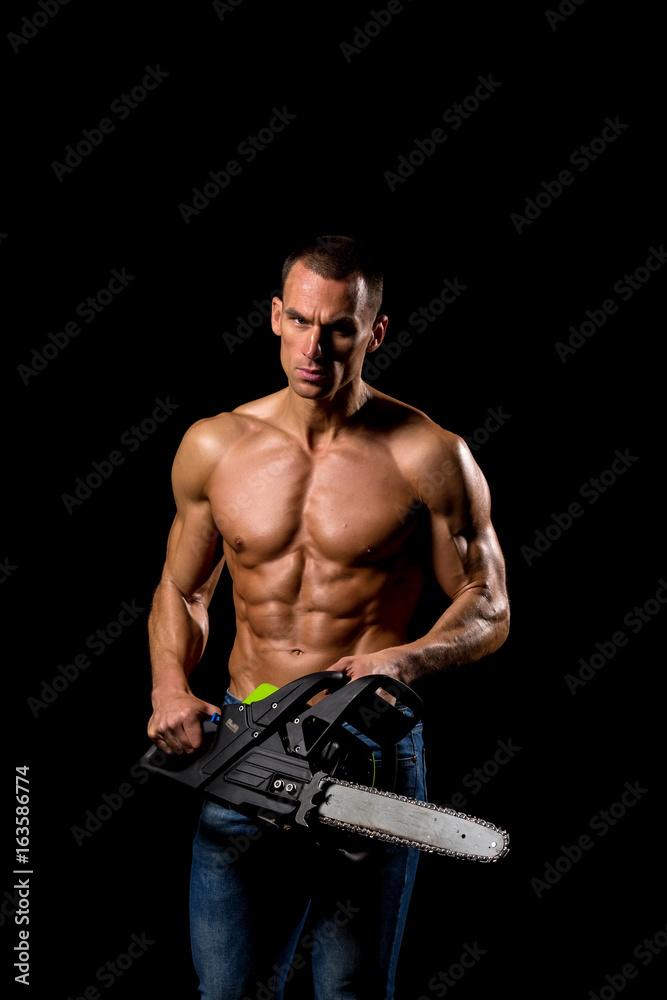 fitness muscular male model with chainsaw Stock Photo | Adobe Stock
