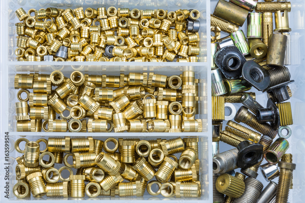Different types and sizes of thread inserts in small transparent box ...