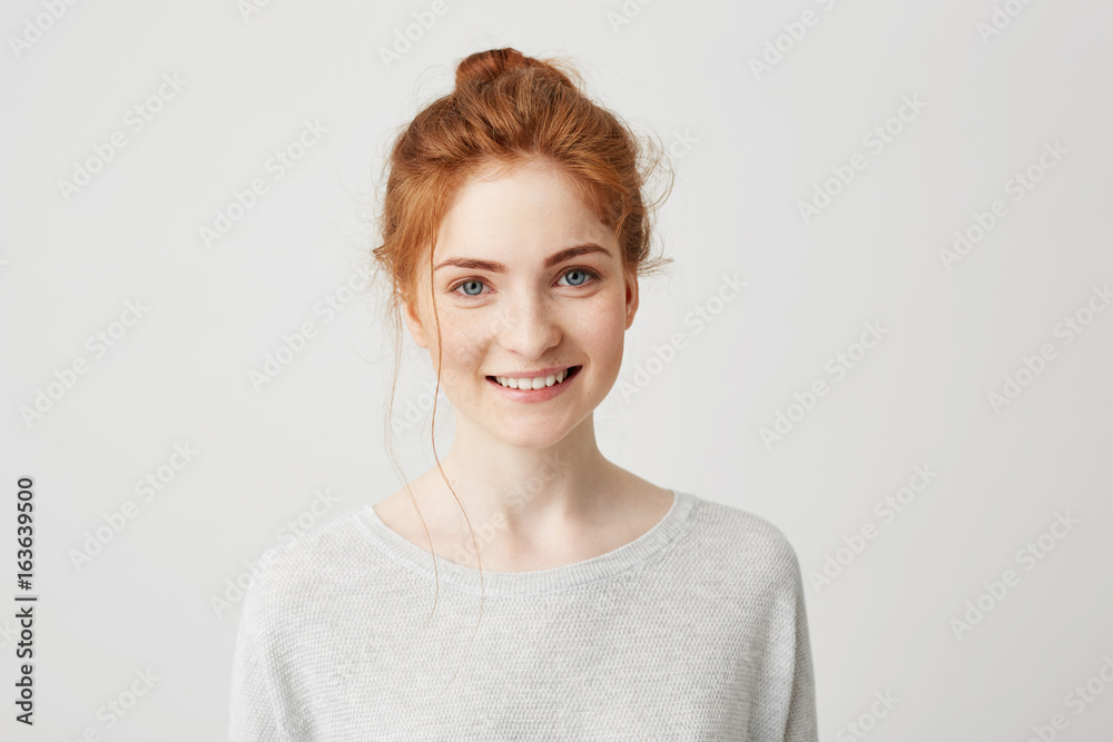 Portrait of happy tender ginger girl with blue eyes and freckles ...