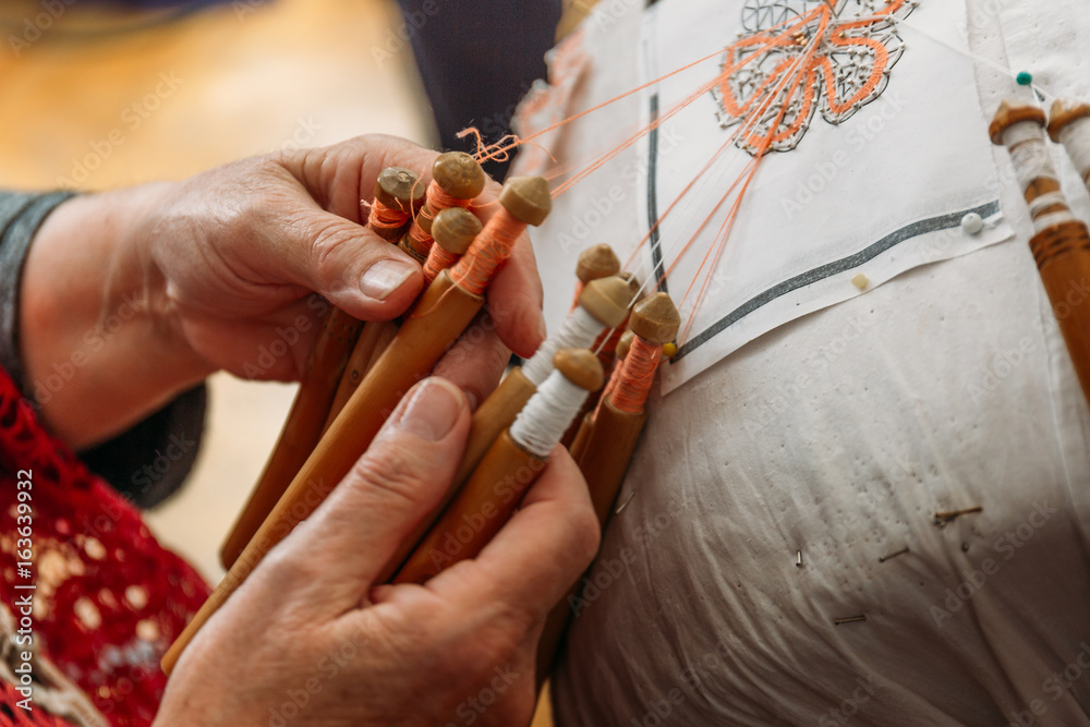 Needlework concept, old craft woman makes bobbin lacing or Palickovanie ...