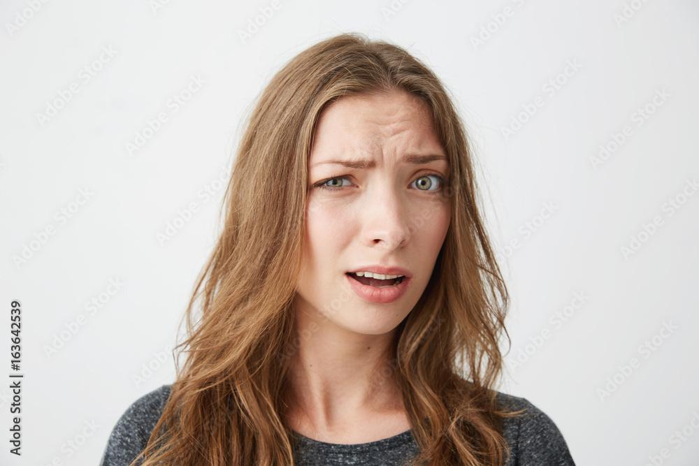 Portrait of young beautiful girl looking at camera suspiciously with ...