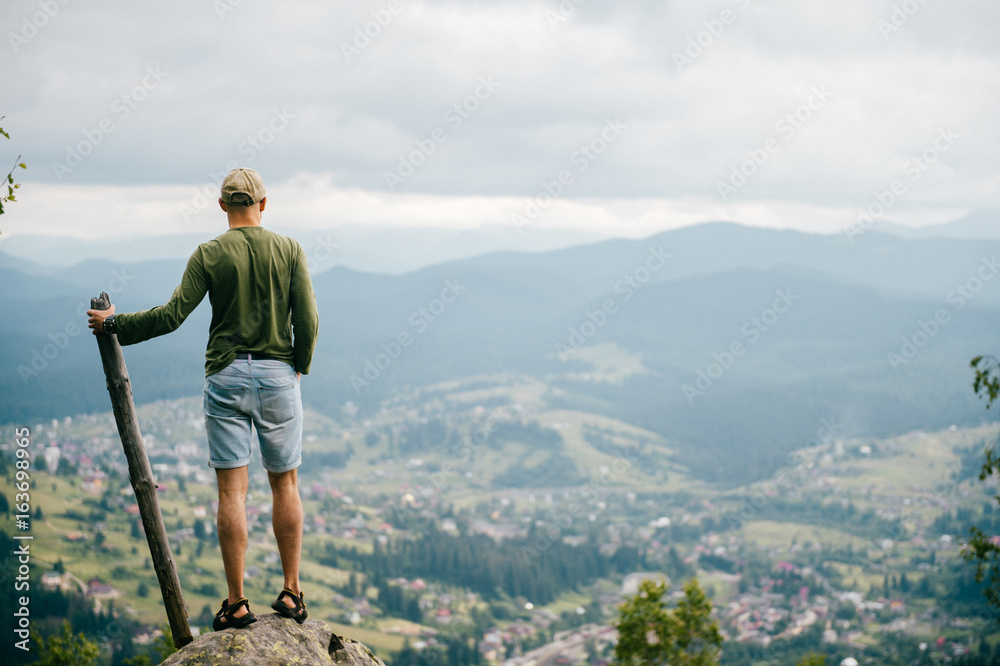 Strong man with wooden staff stick looking far at horizon. Primal ...