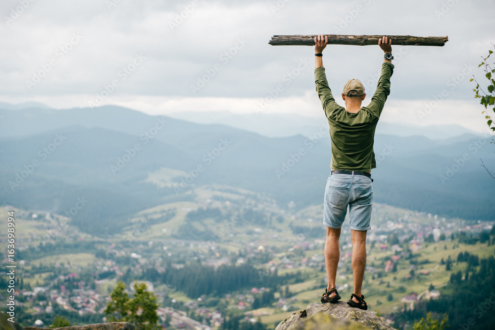 Strong man with wooden staff stick looking far at horizon. Primal ...