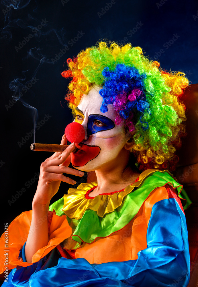 Evil clown on black background. Mad woman is smoking cigar. Portrait of ...