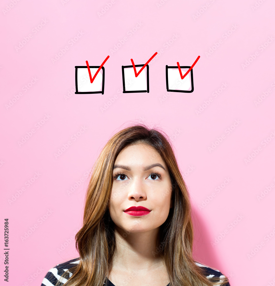 Checklist with young woman on a pink background Stock Photo | Adobe Stock