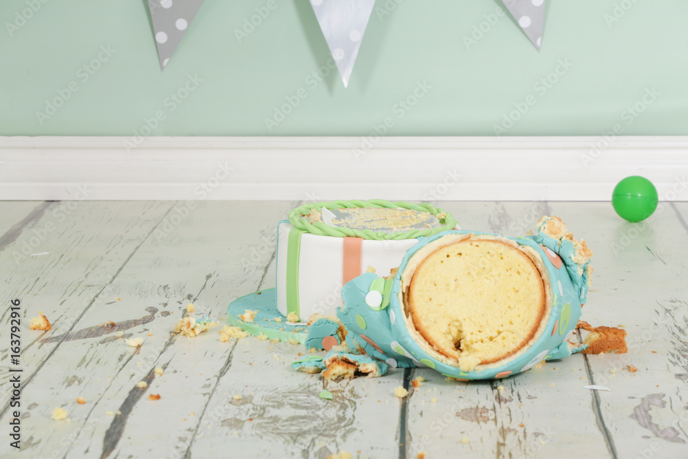 smashed up green, white and orange birthday cake with huge mess and ...