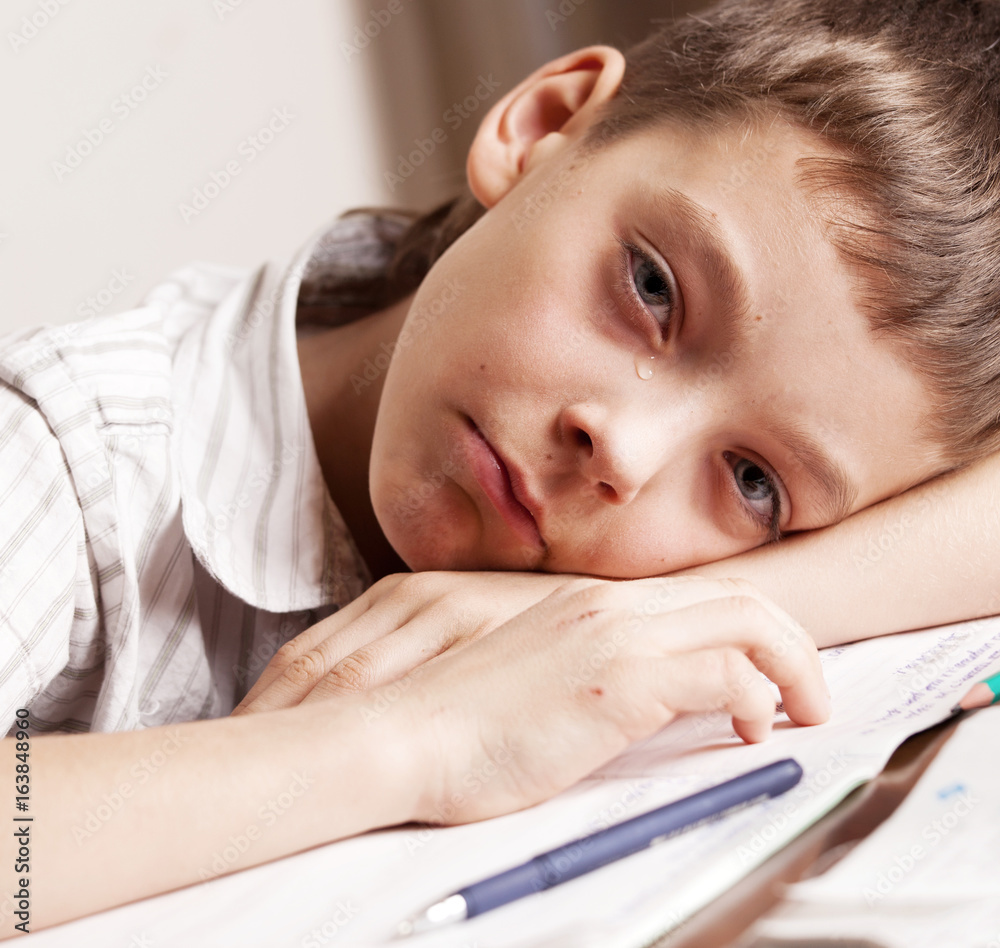 Sad boy doing homework Stock Photo | Adobe Stock