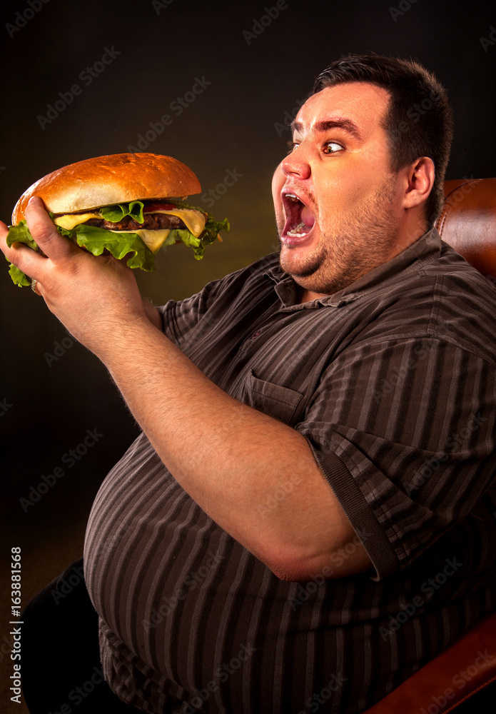 Diet failure of fat man with fast food hamberger. Overweight person who ...