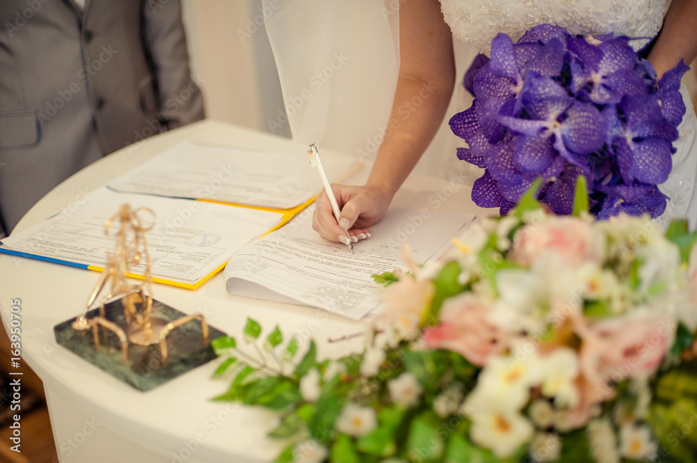 Signature Ceremony. The bride and groom sign the documents about the ...