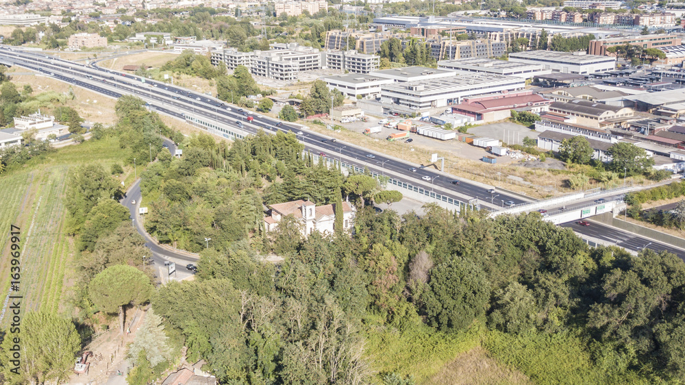 Vista aerea di un autostrada italiana che collega due grandi città. Le ...