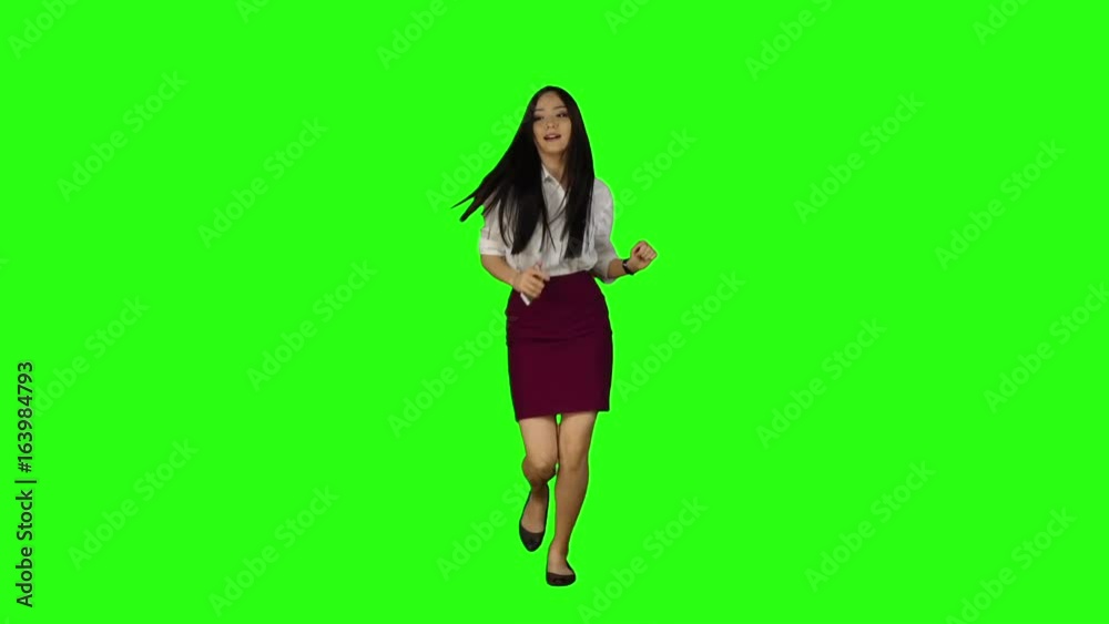 Asian girl walking along the road, looking at the clock starts to run ...