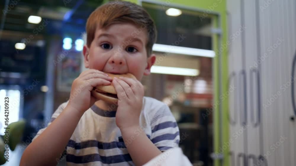 Child eating food for dinner, French fries and burger for lunch for ...
