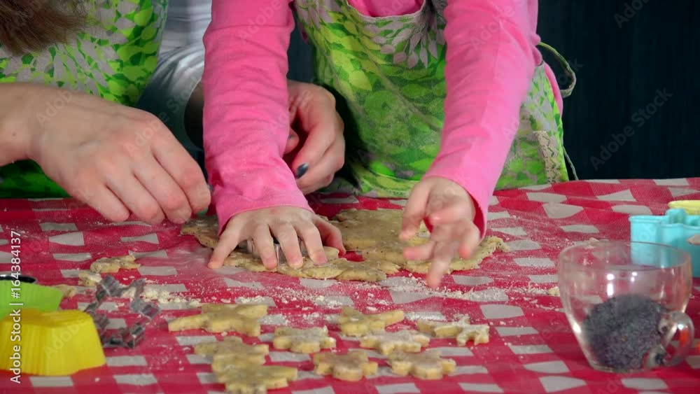 Little girl and adult woman hands making cookies with metallic forms ...