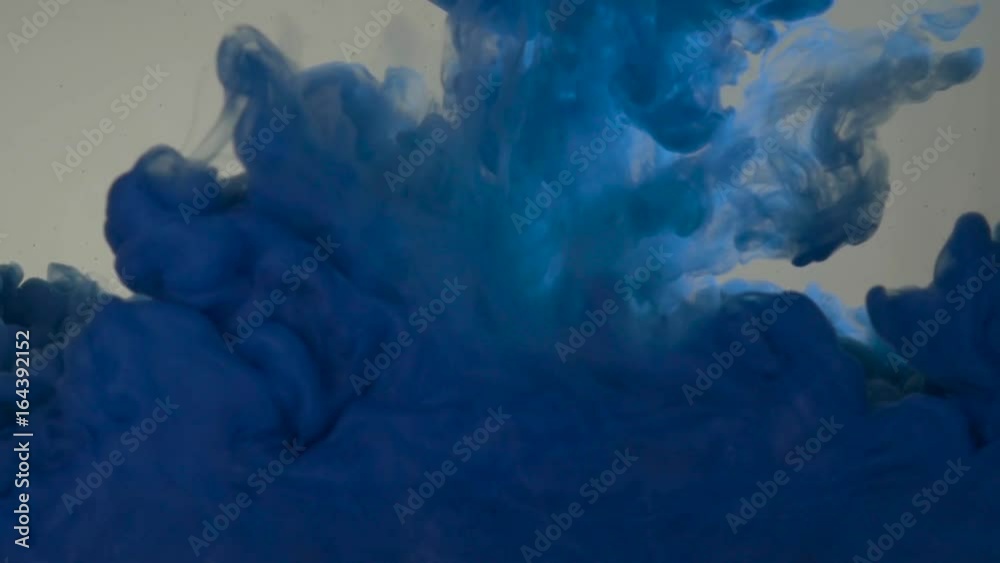 Blue color paint pouring in water. Acrylic colors and ink in water ...