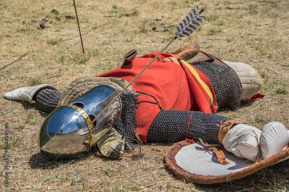 Medieval knight fallen in battle, with an arrow piercing his helmet and ...