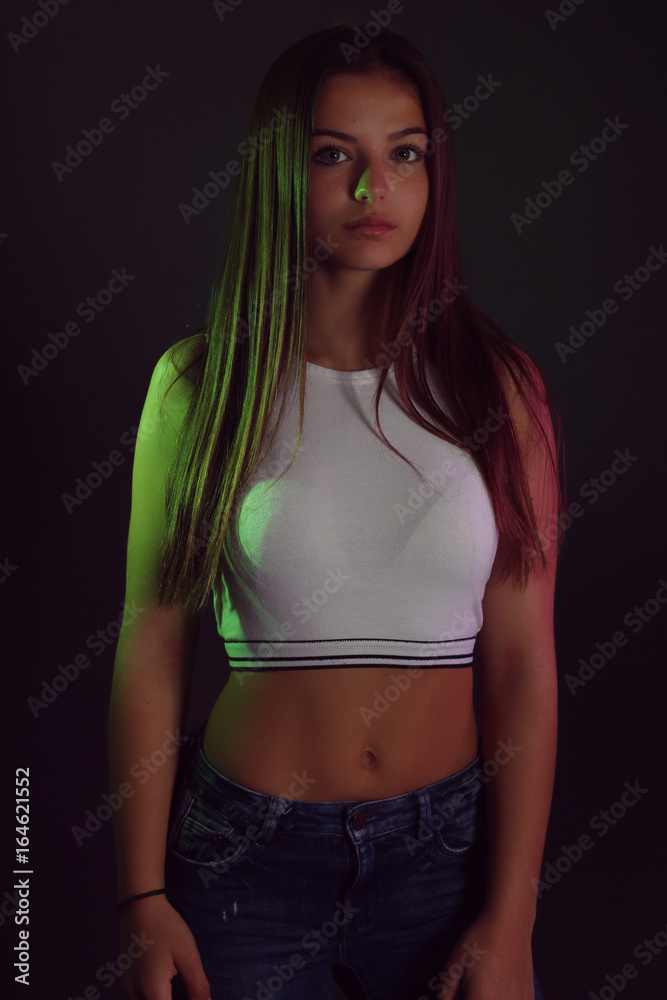 Belle jeune adolescente posant sur un fond gris. Jeune ado à la mode ...