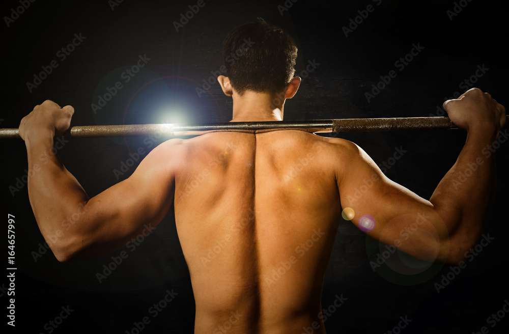 Back view of fitness and bodybuilder man lifting the barbell, showing ...
