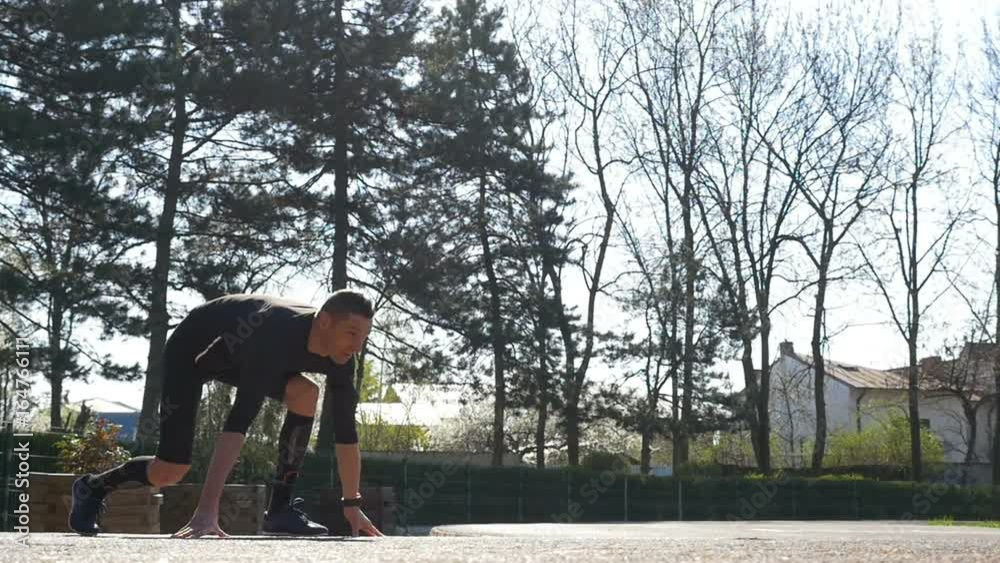 Slow motion of fit runner starting running from block start position on ...