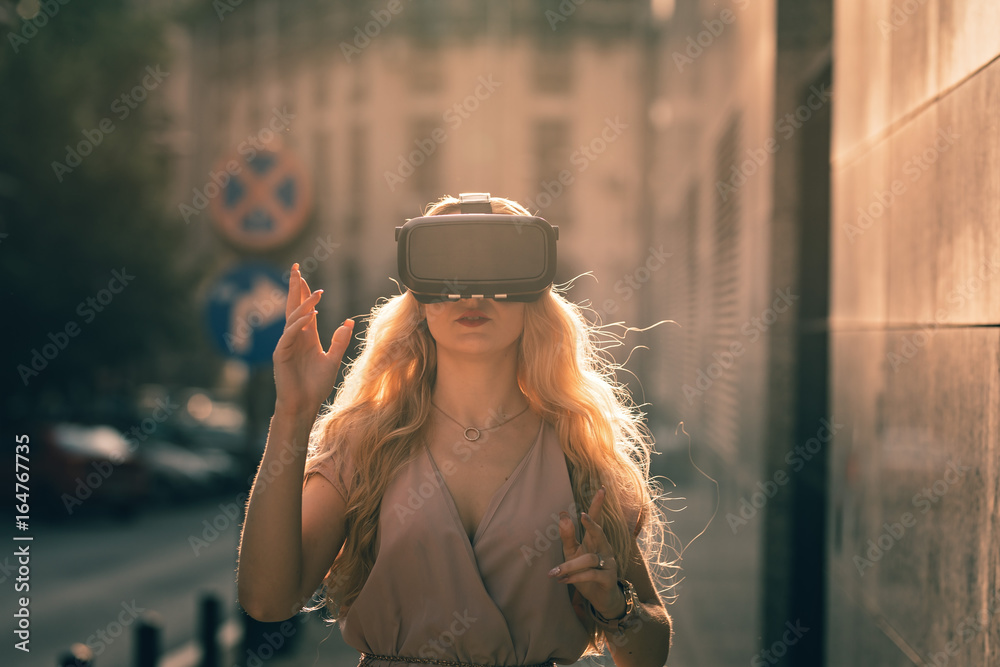 Blonde girl using cool VR set to experience living in fantasy computer ...