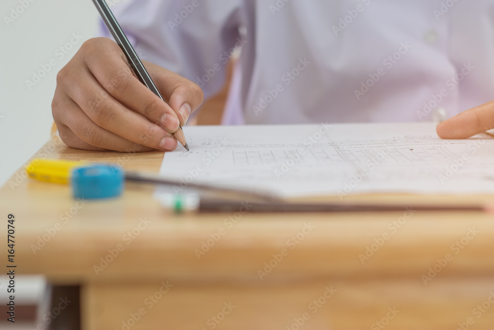 Asian girl students hand holding pen writing fill in Exams paper sheet ...