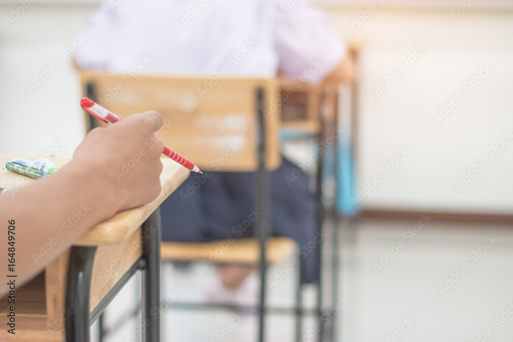 Blurred of Asian students hand holding pen for writing Exams paper ...