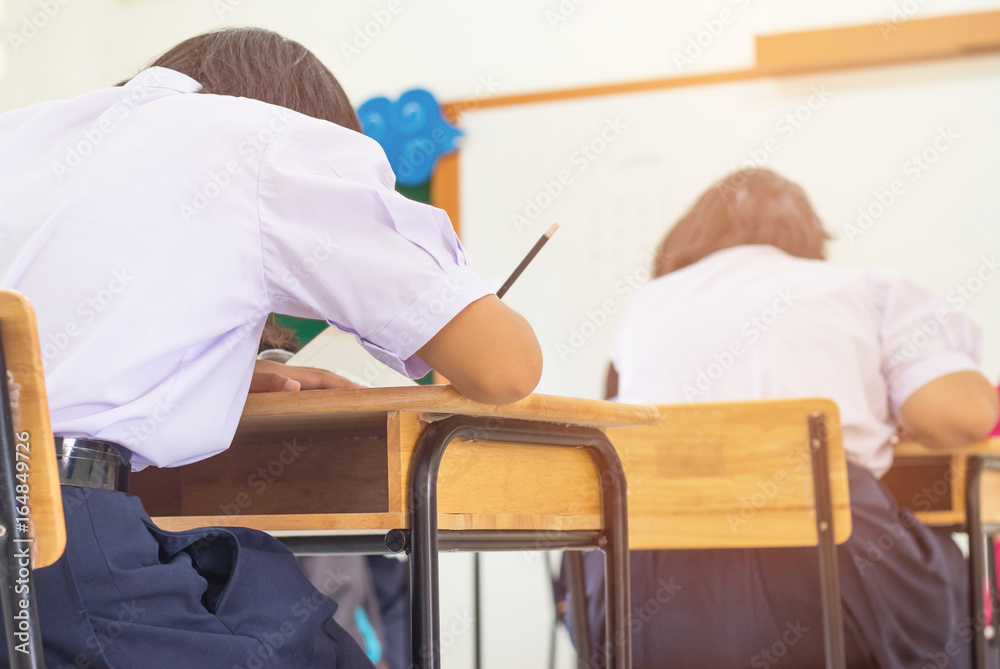 Asian girl students sitting on row wood desk table with Exams paper ...