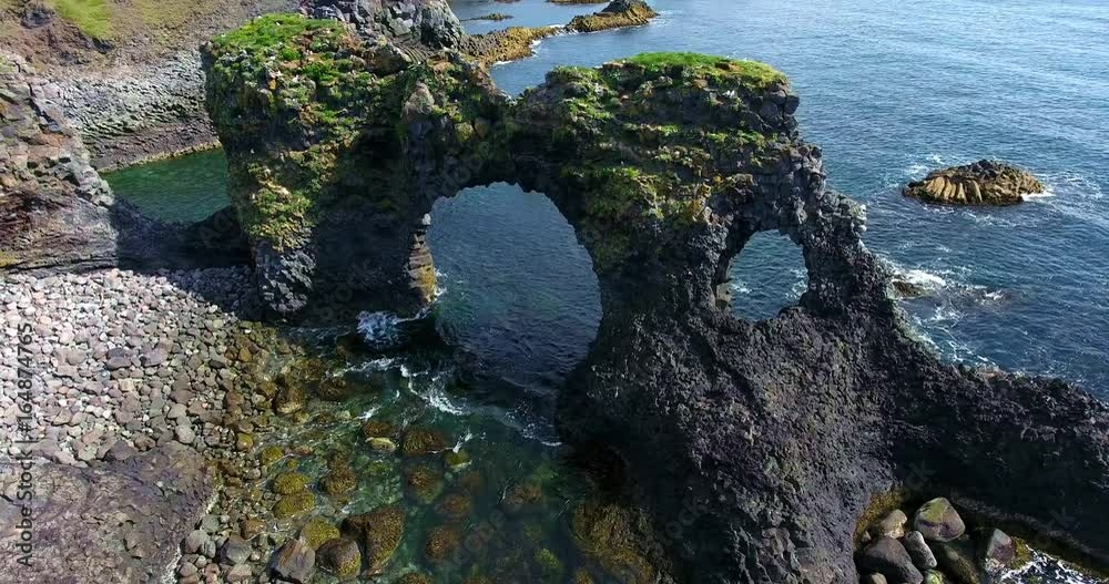 Rotating Aerial Of Rocky Sea Arches On The Beach With Birds Flying ...