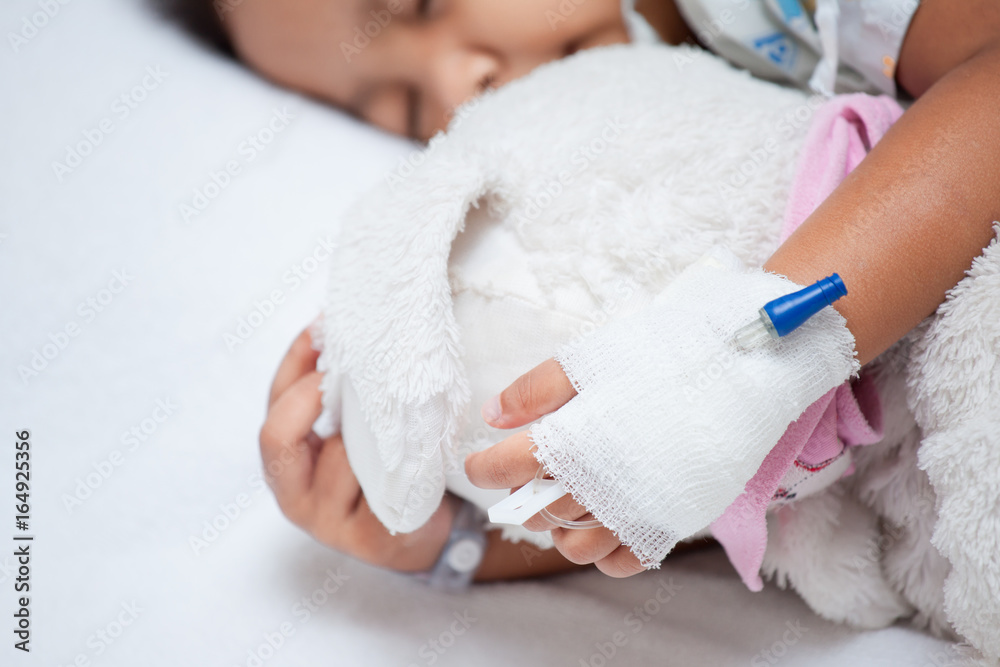 Sick child girl's hand with saline intravenous (iv) drip hugging her ...