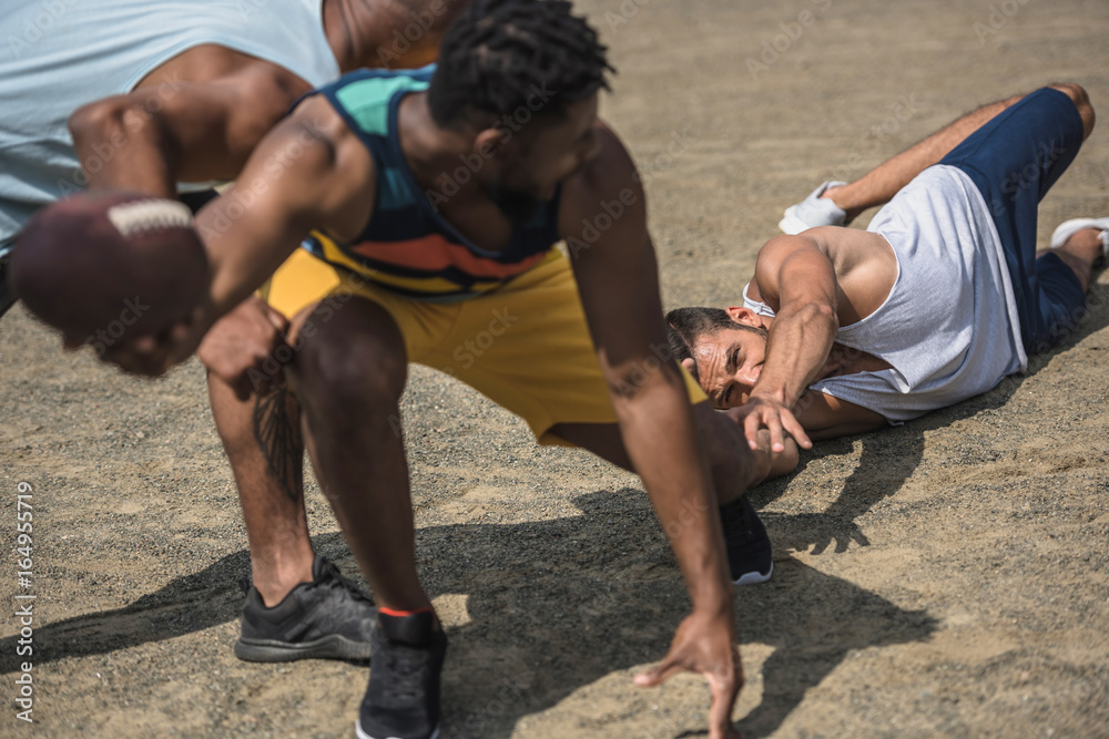 group of young multicultural men playing football on court Stock Photo ...